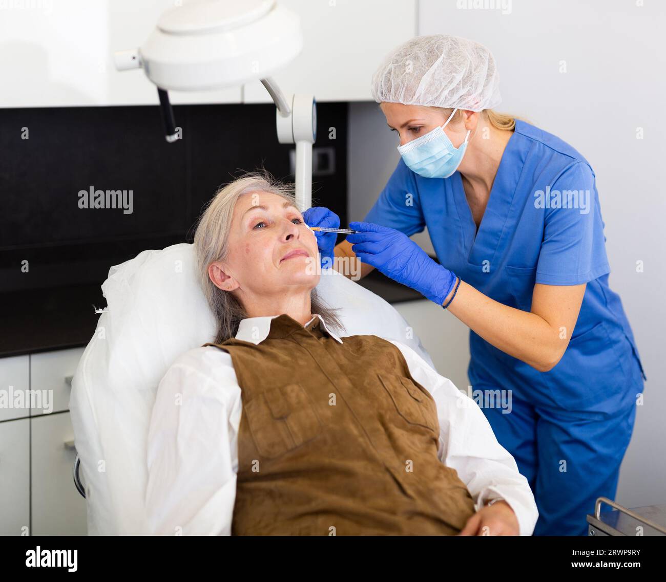 Cosmetologist doing botulotoxin injections for senior woman Stock Photo ...