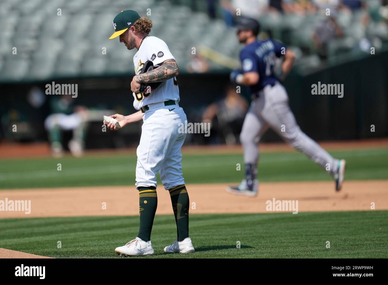 Oakland Athletics pitcher Joey Estes, left, reacts after allowing a ...