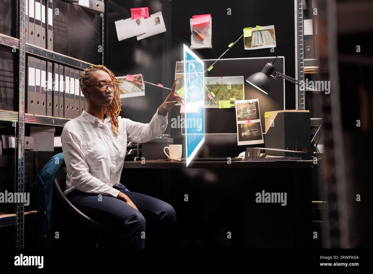 Female investigator looking at evidence hologram, examining artificial ...