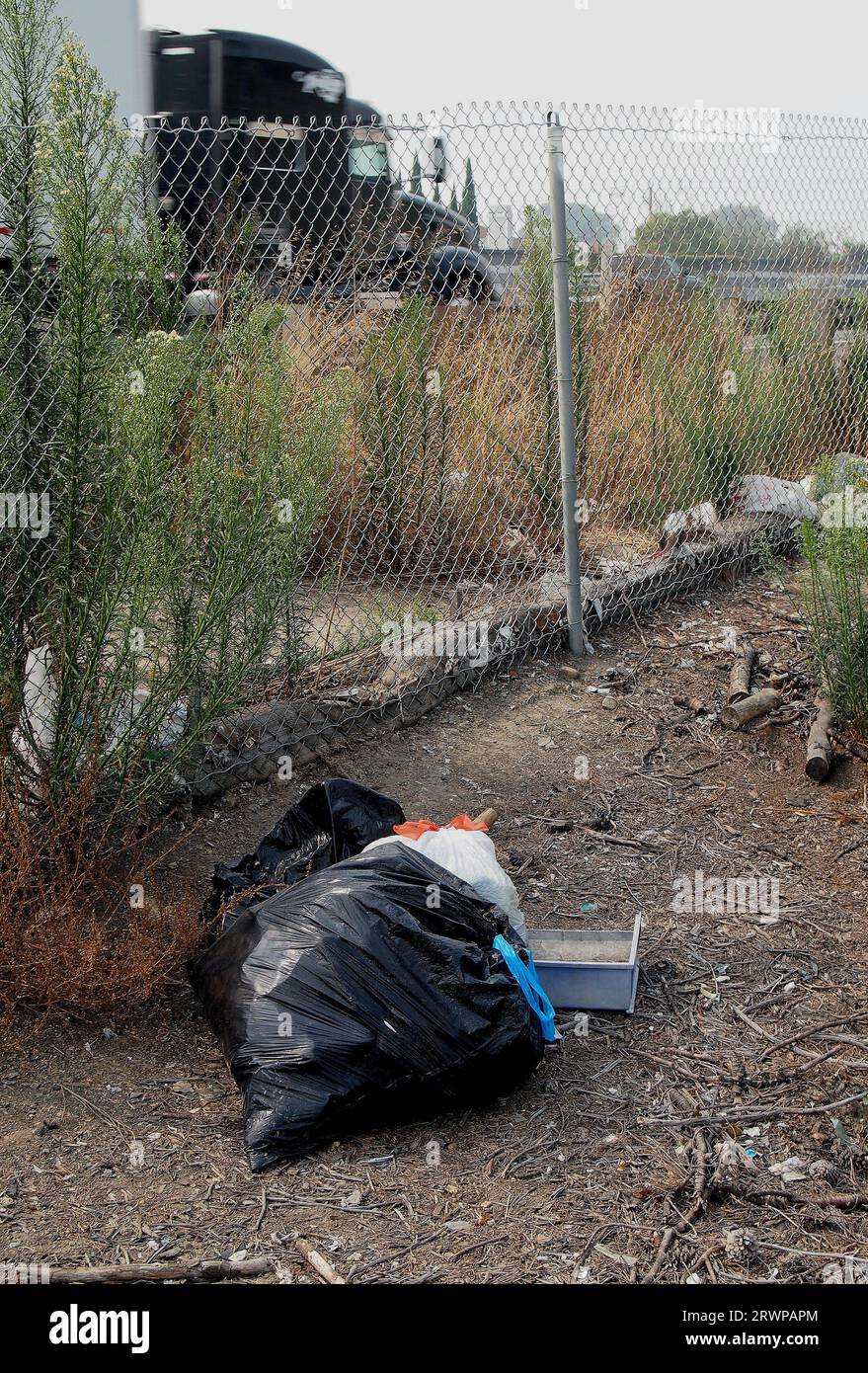 plastic bags of trash dumped along the 880 freeway at the Alameda Creek ...