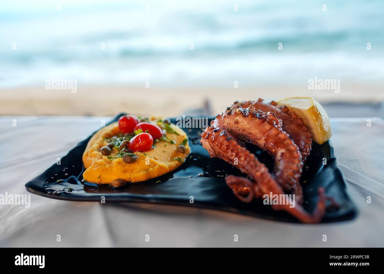 Seafood. Octopus with puree on a table in a restaurant Stock Photo - Alamy