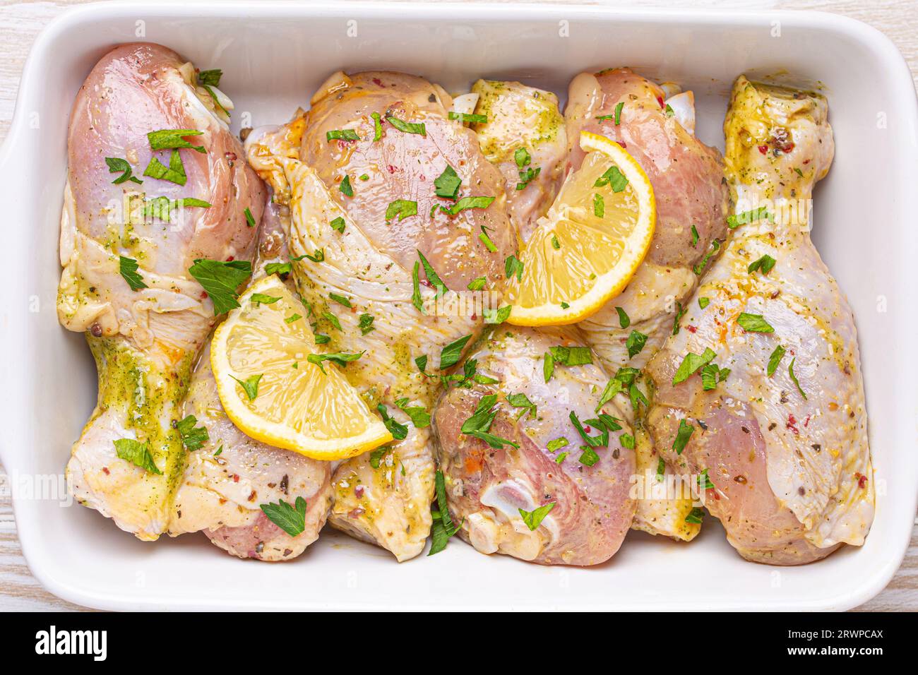Raw uncooked chicken legs marinated with seasonings, herbs, lemon in ...