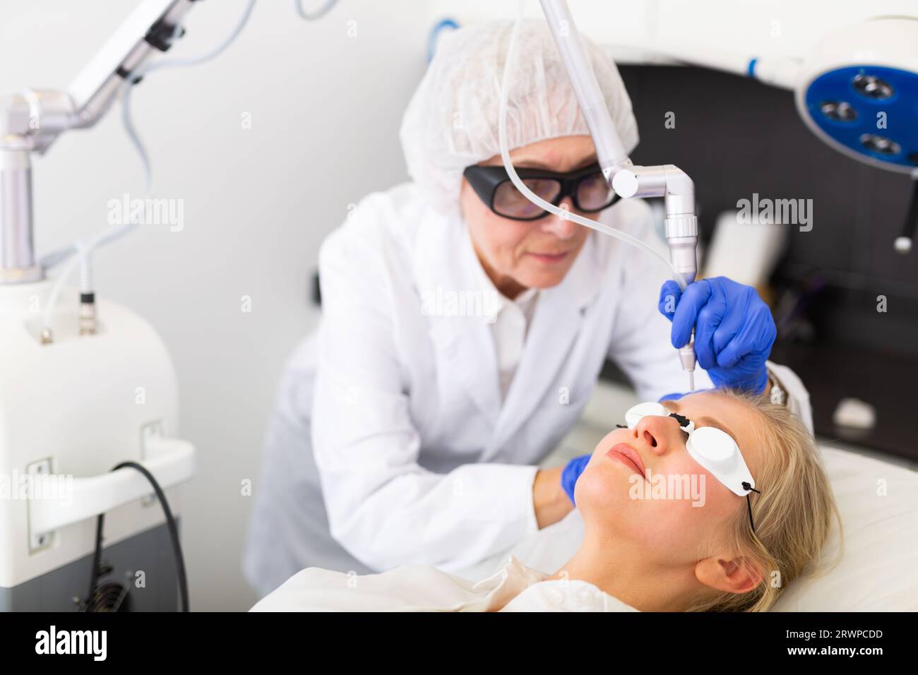 Female client receiving face skin laser resurfacing at cosmetology ...