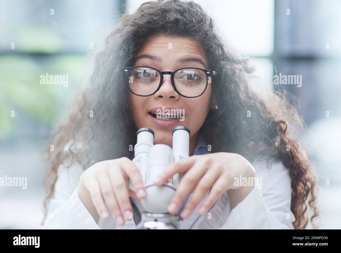 Attractive female scientist looking through a microscope Stock Photo ...