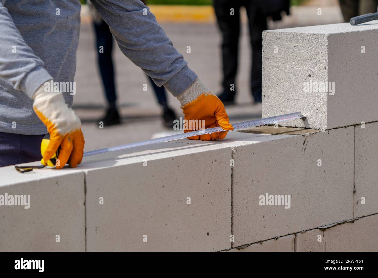 The bricklayer works to measure. Measuring with a meter Stock Photo - Alamy
