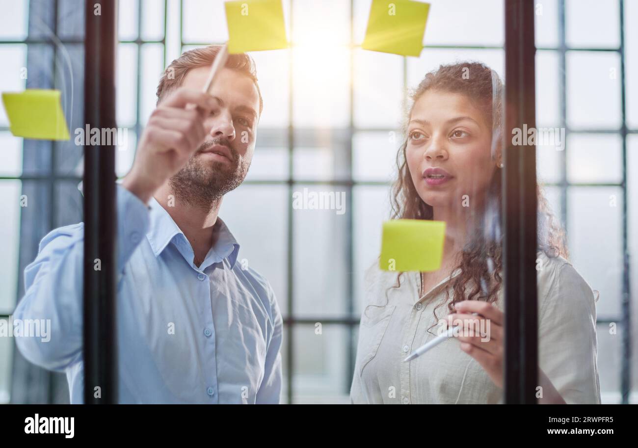 Business people talking in the hallway of the modern office building with employees working ...