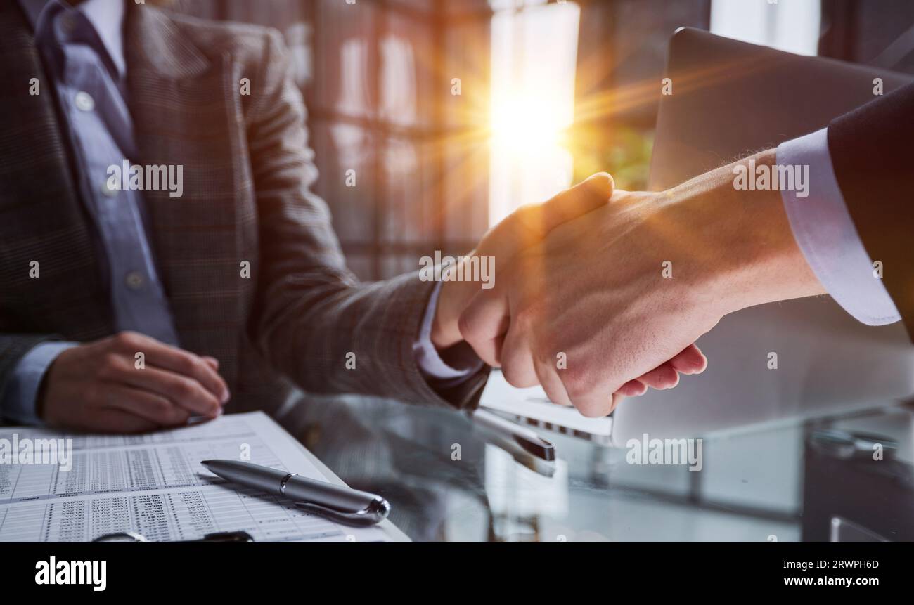 Agent and client shaking hands after signed document and done business ...