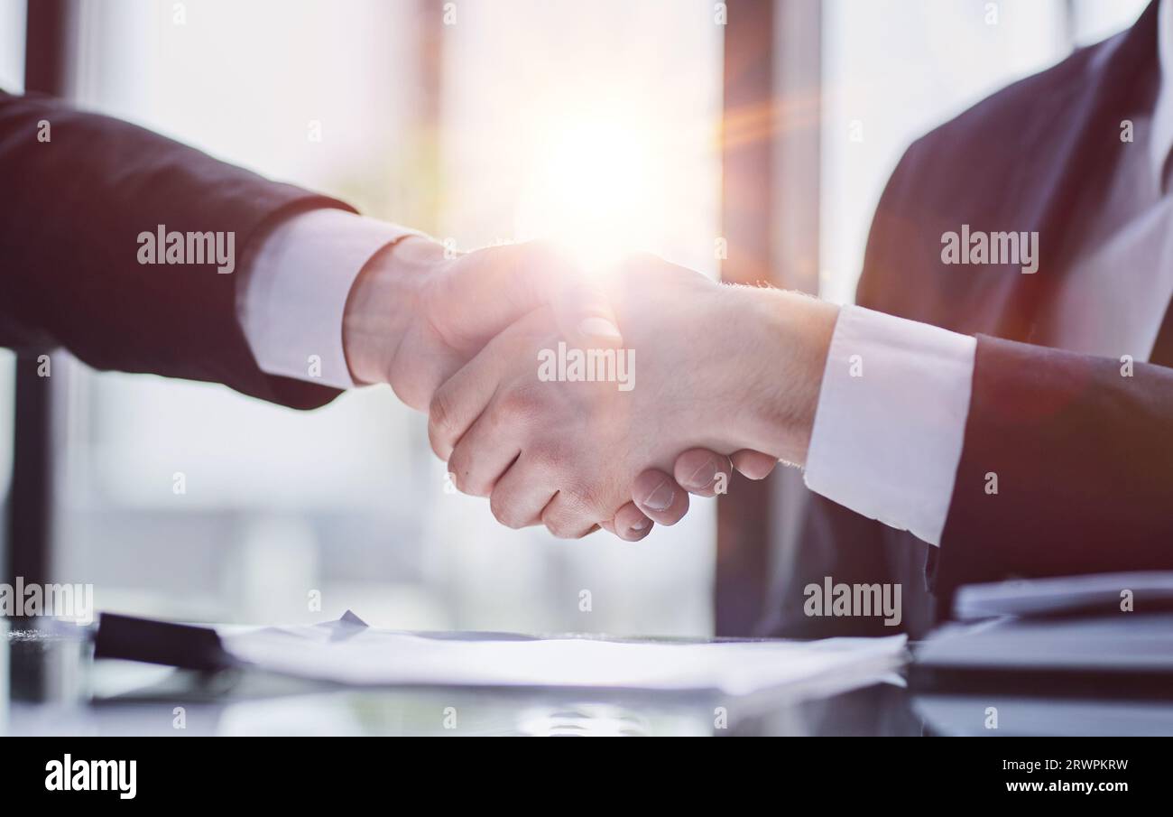 Close up of greeting handshake, young businessman hands shaking over ...