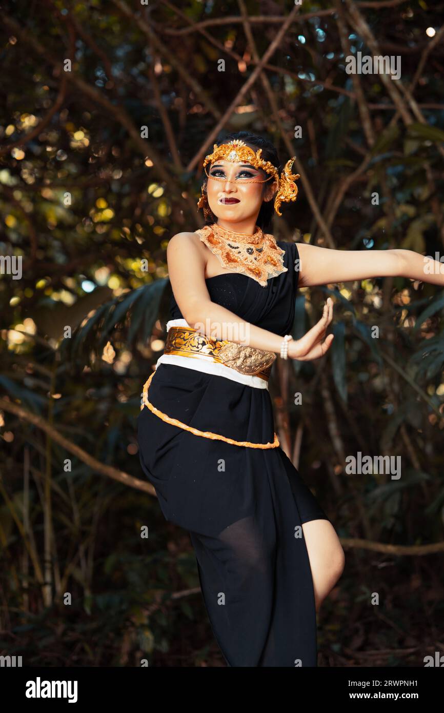 Balinese woman dancing on the top of the rock while wearing a black ...