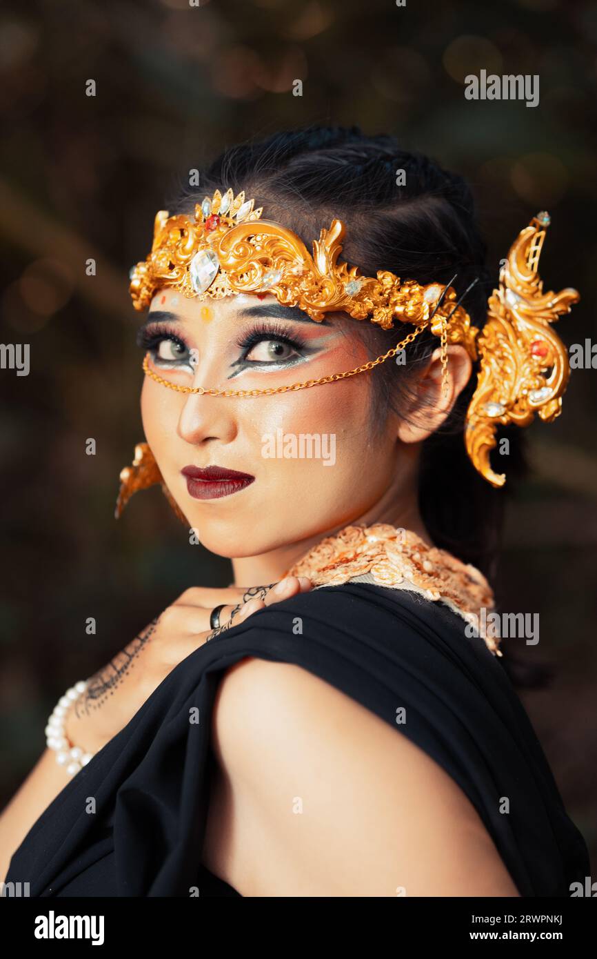 The face of a Balinese woman wearing a gold crown and make-up on her ...