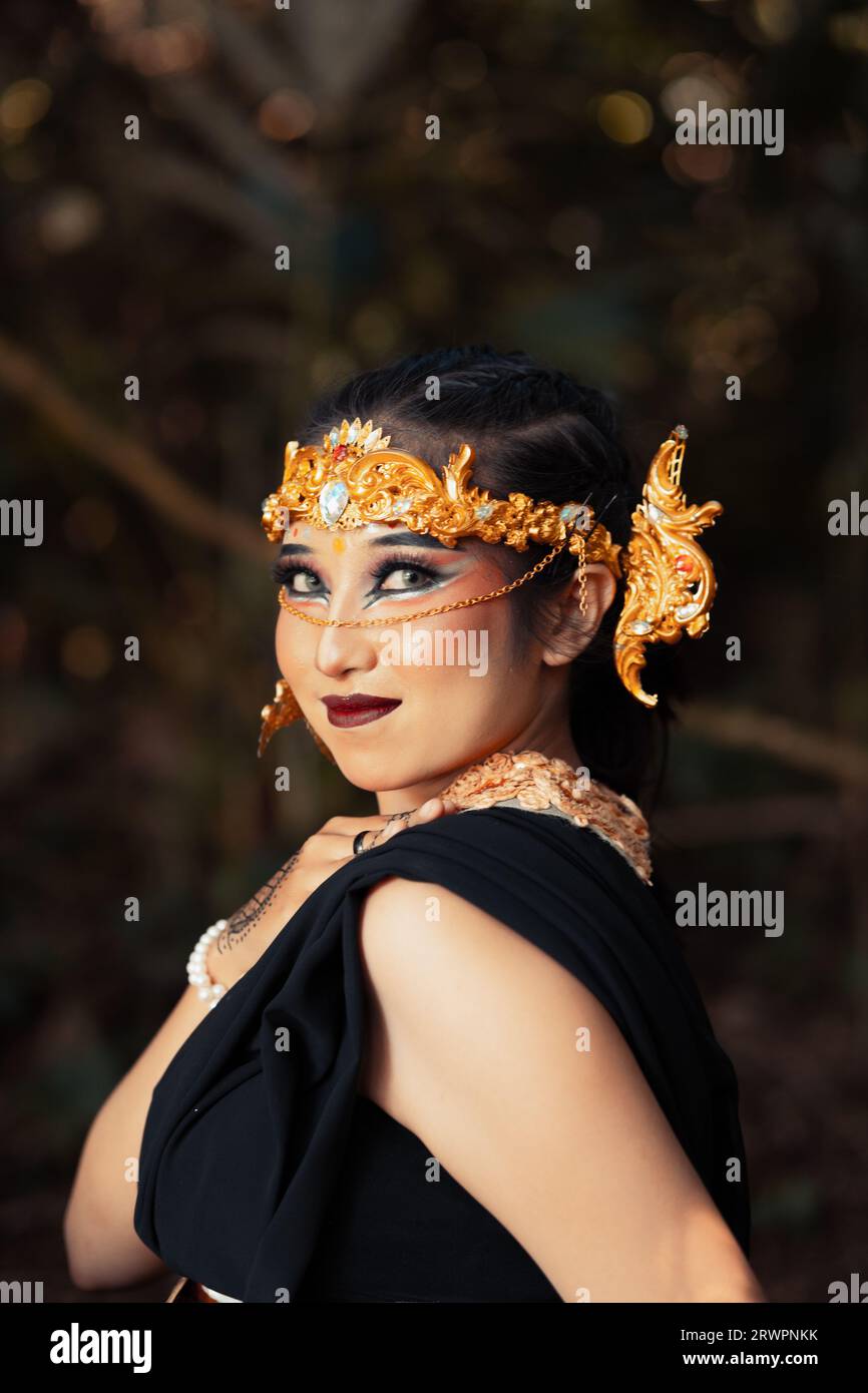 The face of a Balinese woman wearing a gold crown and make-up on her ...