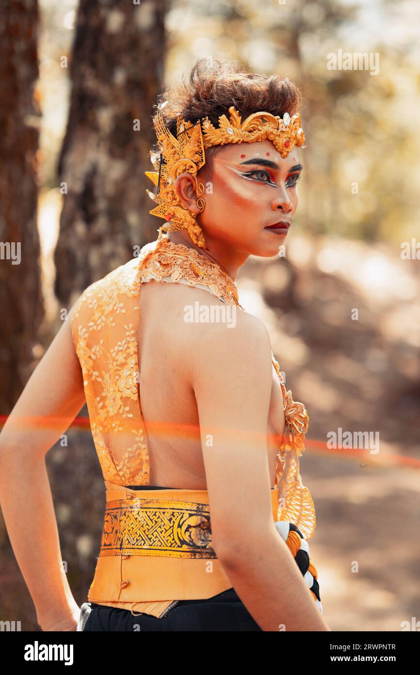 Manly Asian man posing in a golden crown and golden clothes while ...