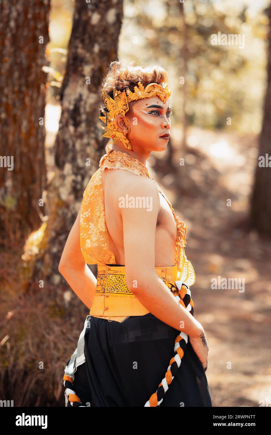 Manly Asian man posing in a golden crown and golden clothes while ...