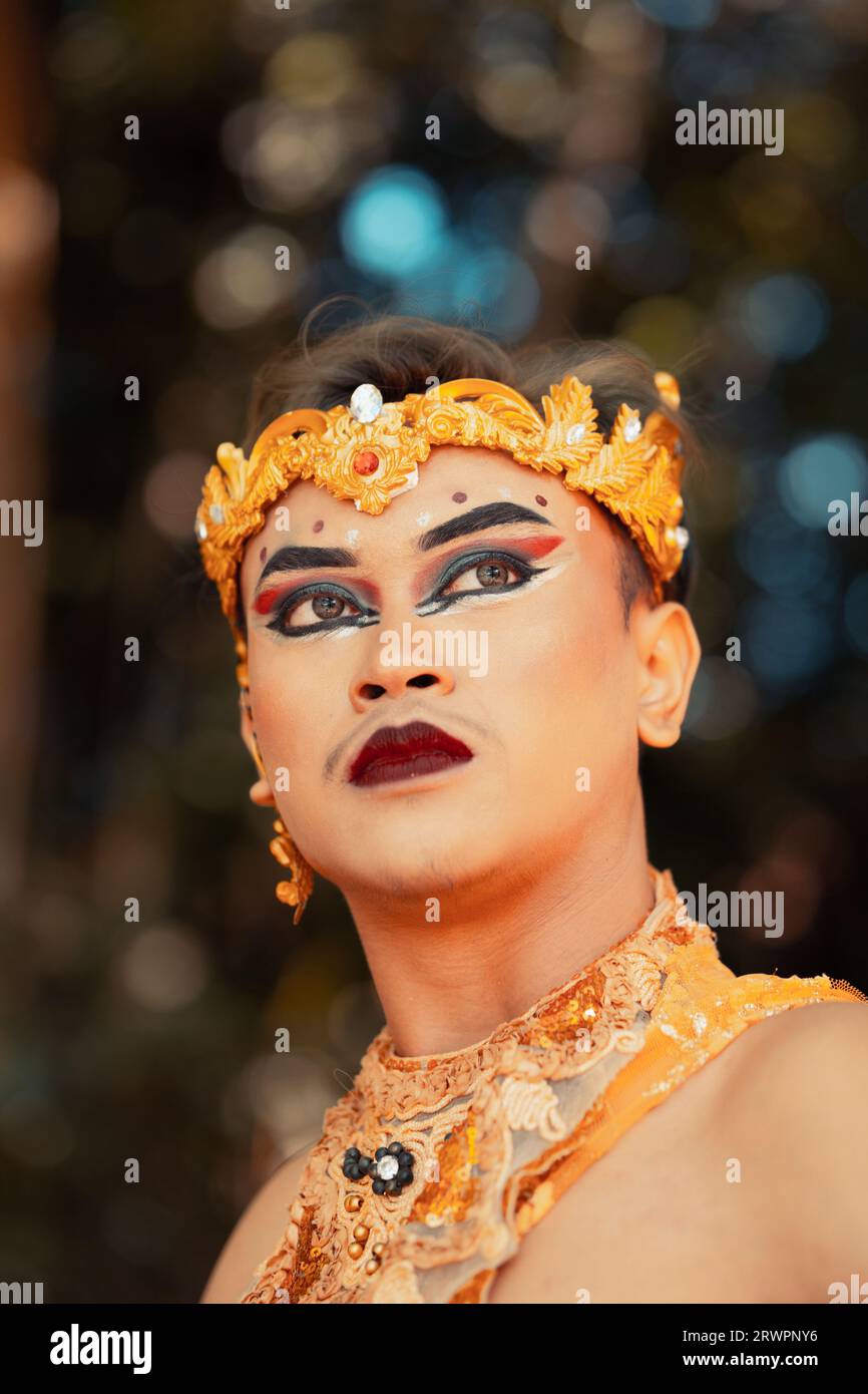 Balinese face in makeup and wearing a golden crown and golden necklace ...