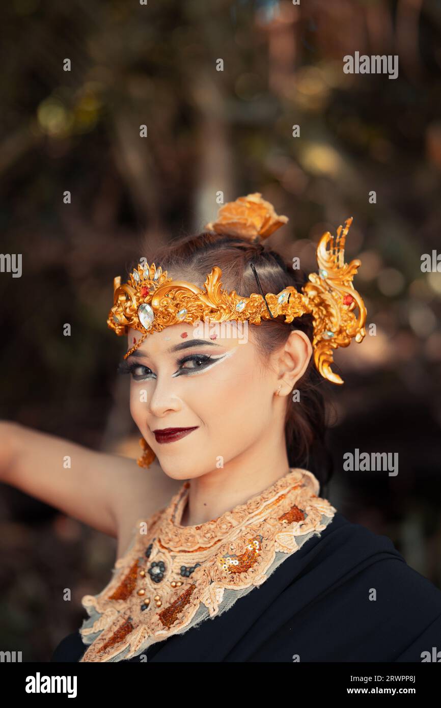 The face of an Asian woman with golden jewelry on her body while ...