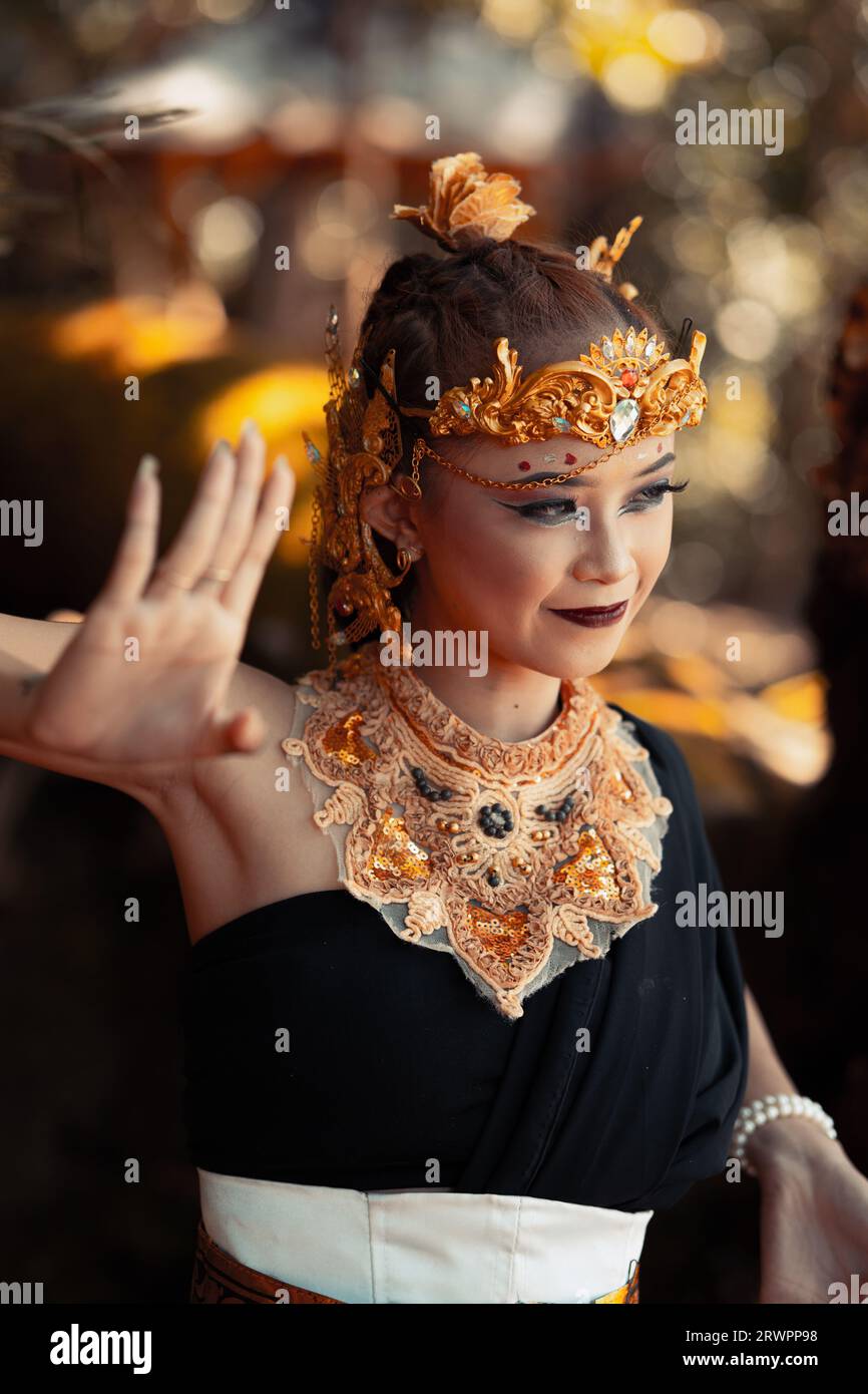 Beautiful tribe woman wearing a gold queen crown while wearing a black costume inside the jungle ...