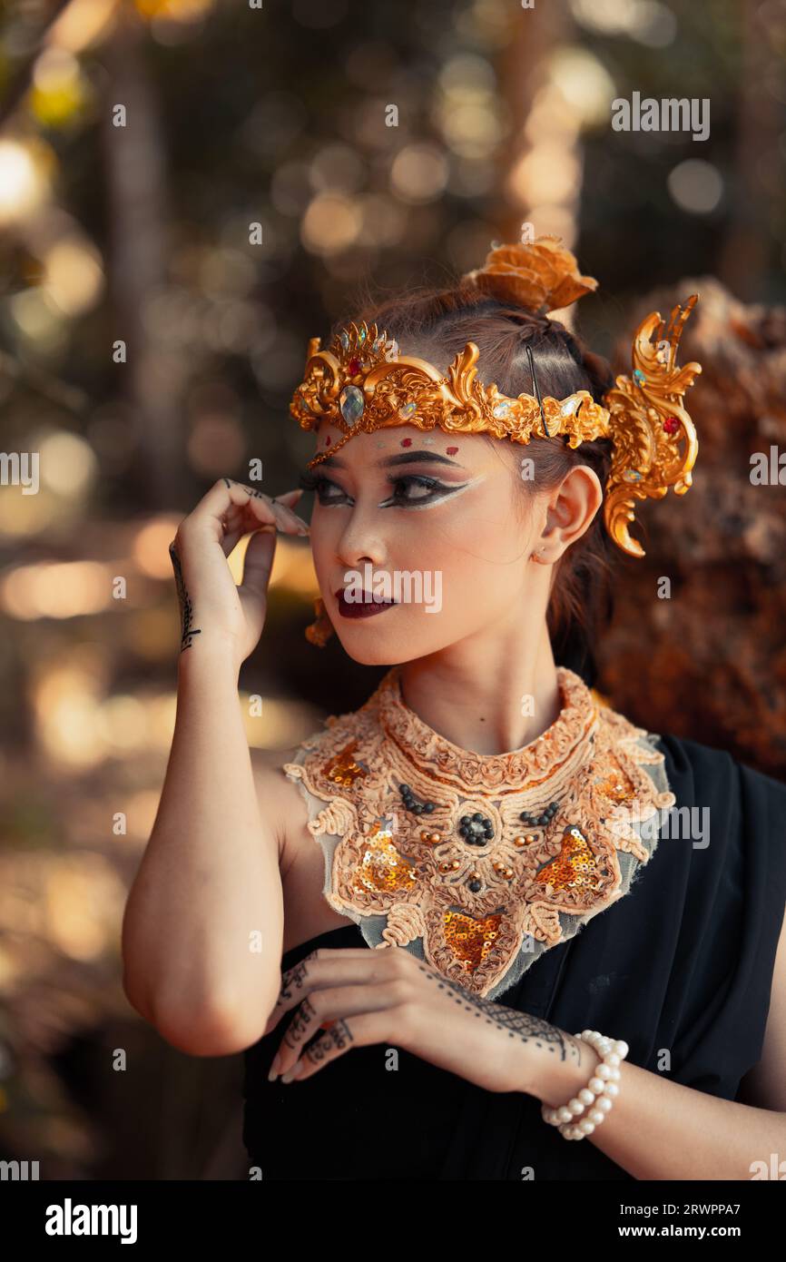 Tribal queen in makeup while wearing a gold crown and gold necklace ...