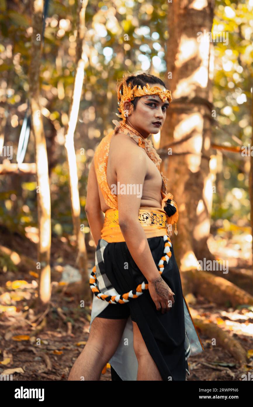 A Tribal Man poses with makeup on her face while wearing gold ...