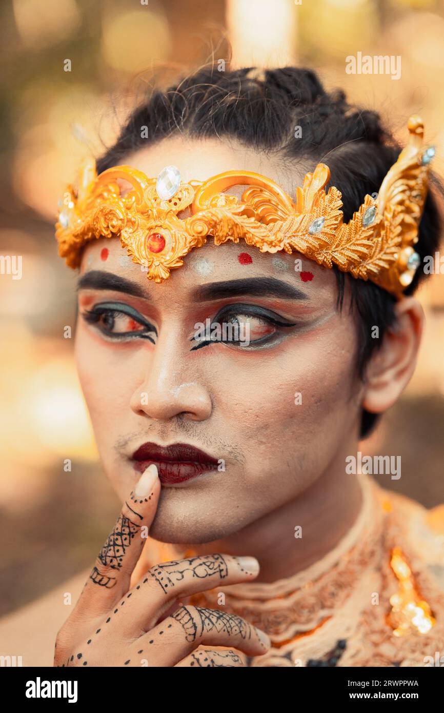 Asian man with a thinking expression while wearing a gold crown and ...