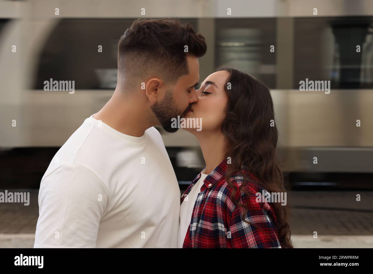 Long-distance relationship. Beautiful couple kissing on platform of railway station Stock Photo ...