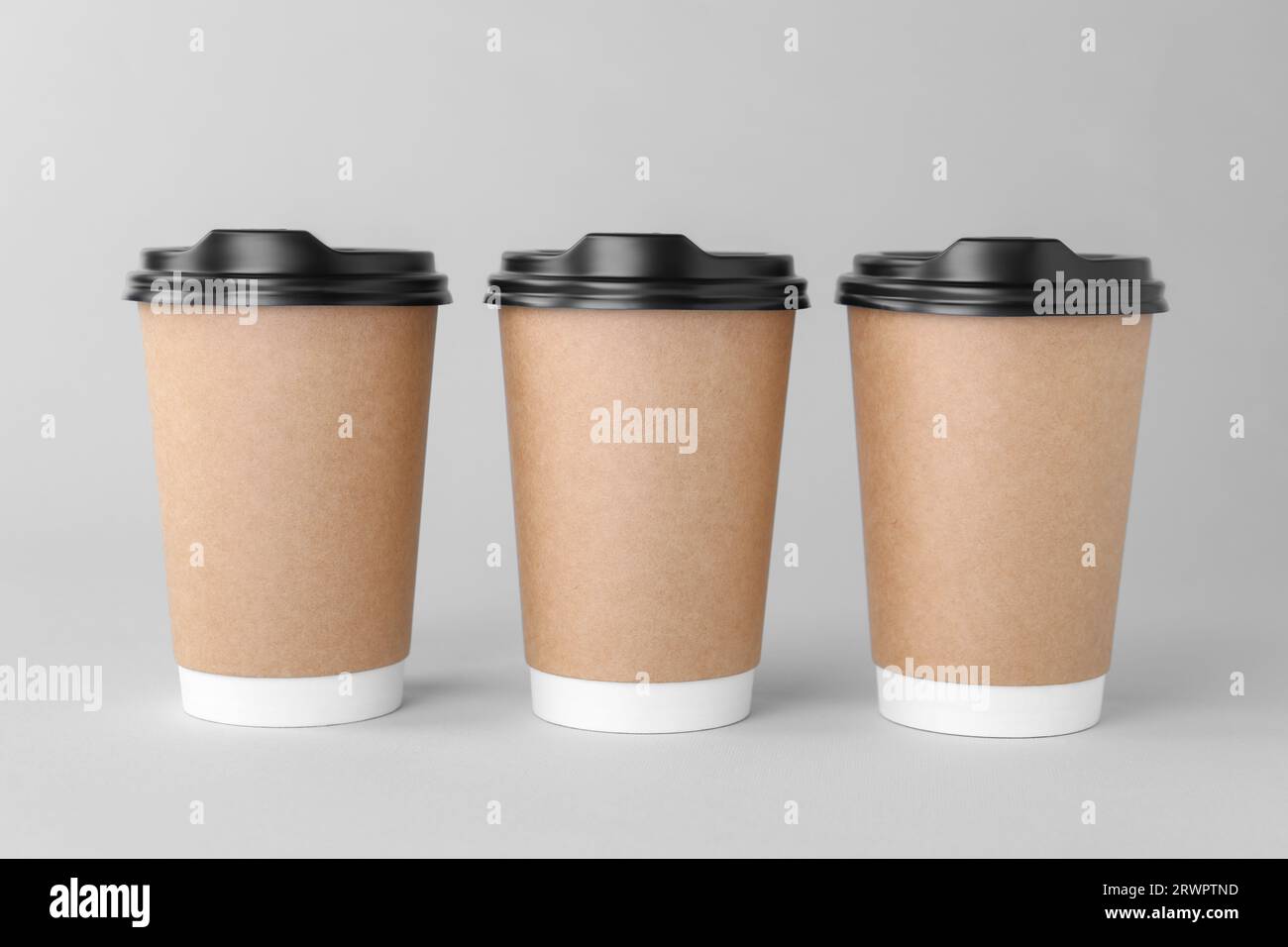 Paper cups with black lids on light grey background. Coffee to go Stock ...