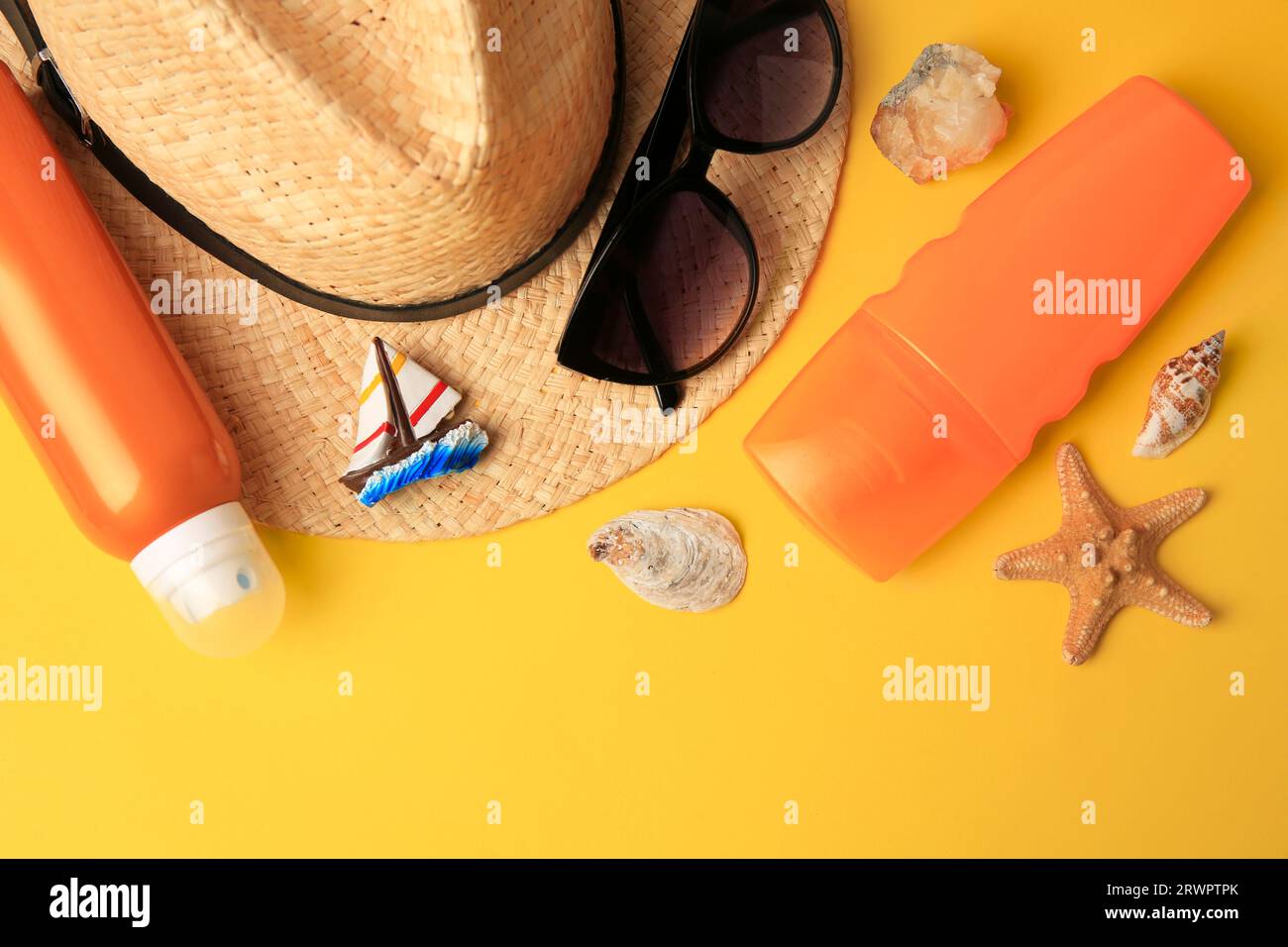 Flat lay composition with bottles of sunscreen on yellow background ...