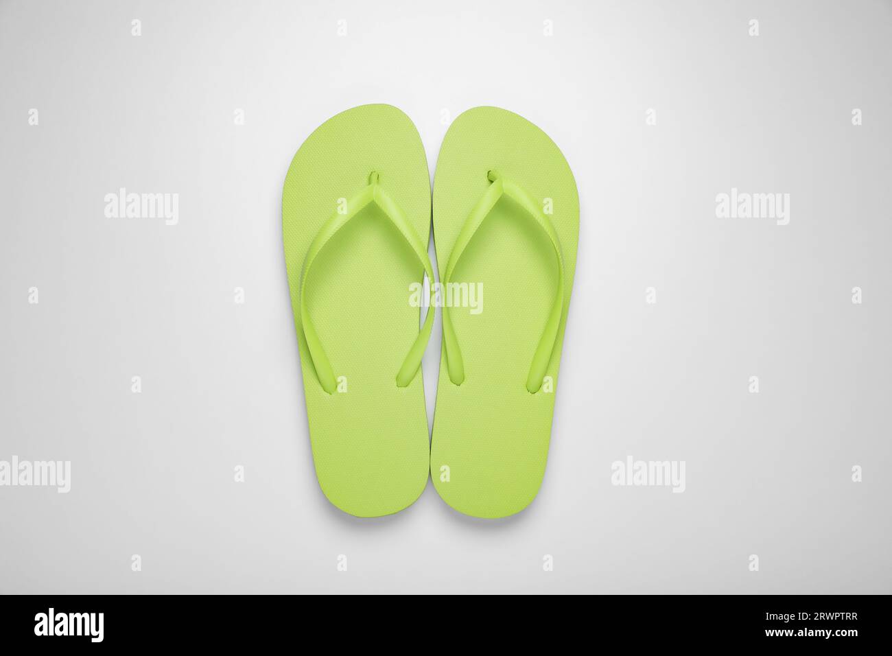 Light green flip flops on white background, top view Stock Photo - Alamy