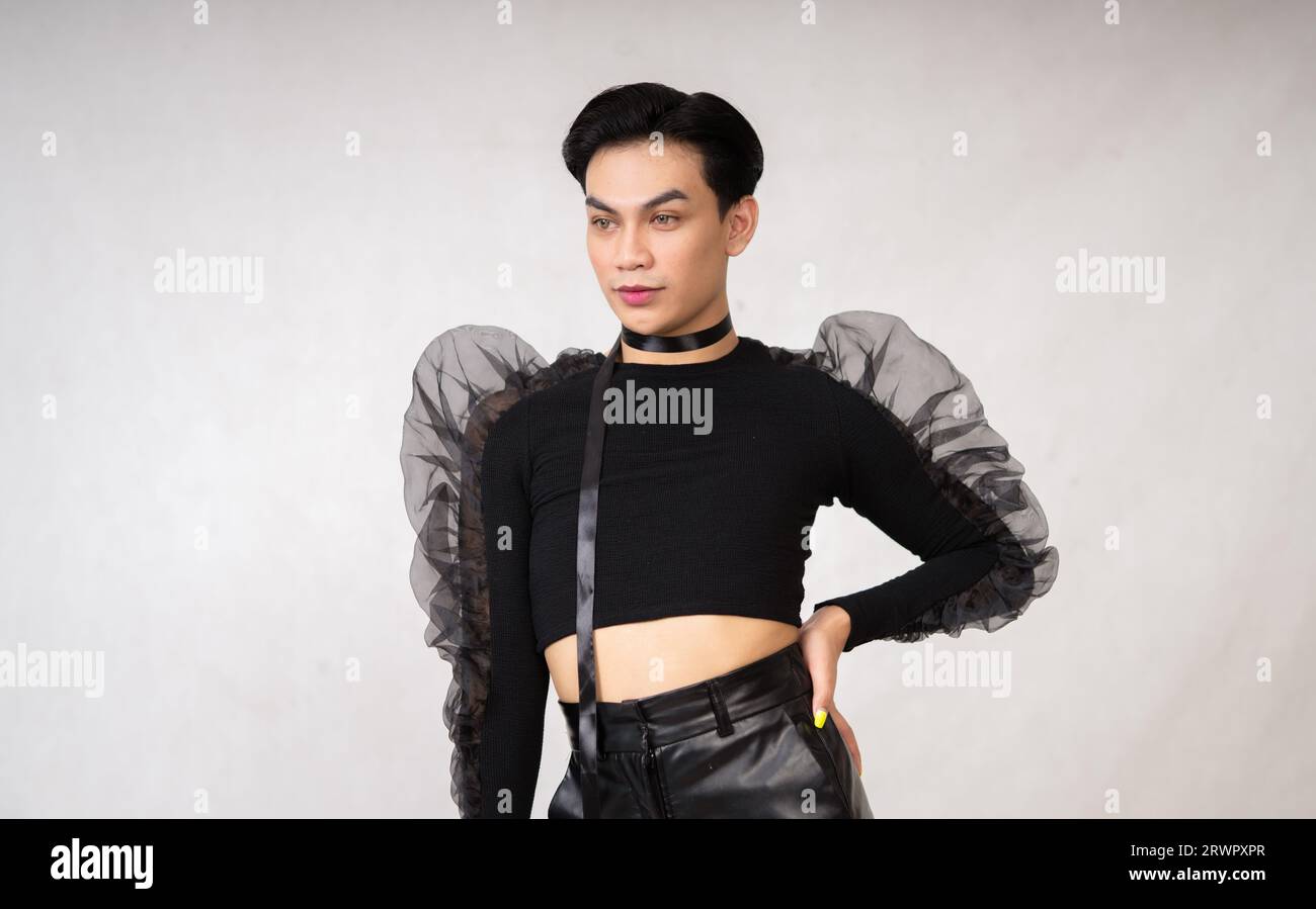 A transgender man poses in a black dress with an elegance face and ...