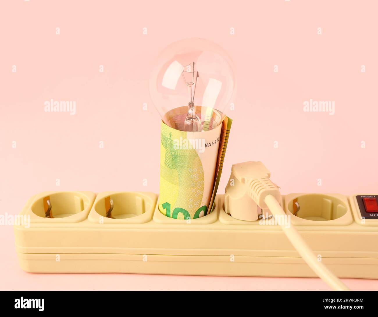 Power socket with money, light bulb and plug on pink background ...