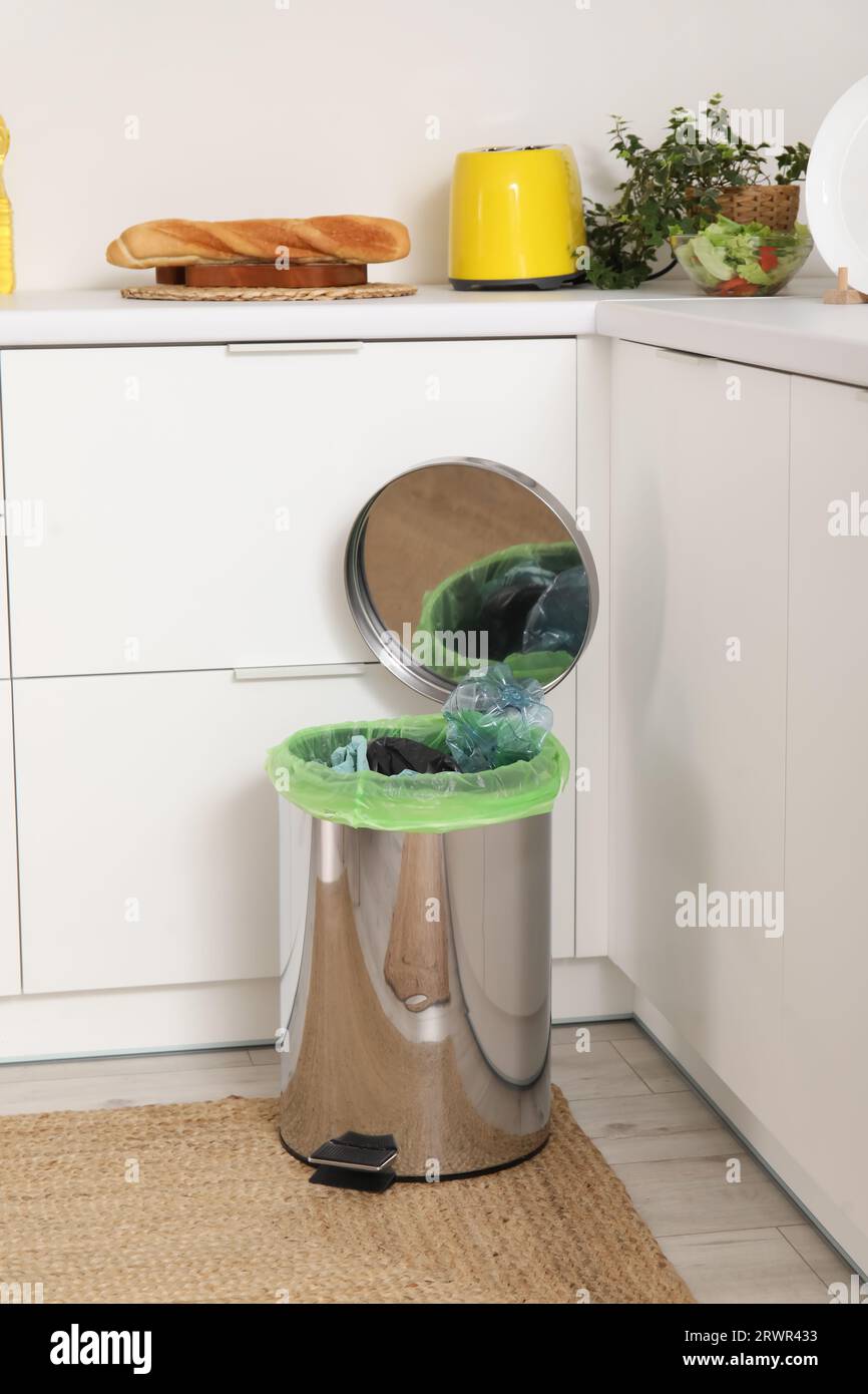 Opened trash bin with garbage in interior of light kitchen Stock Photo ...