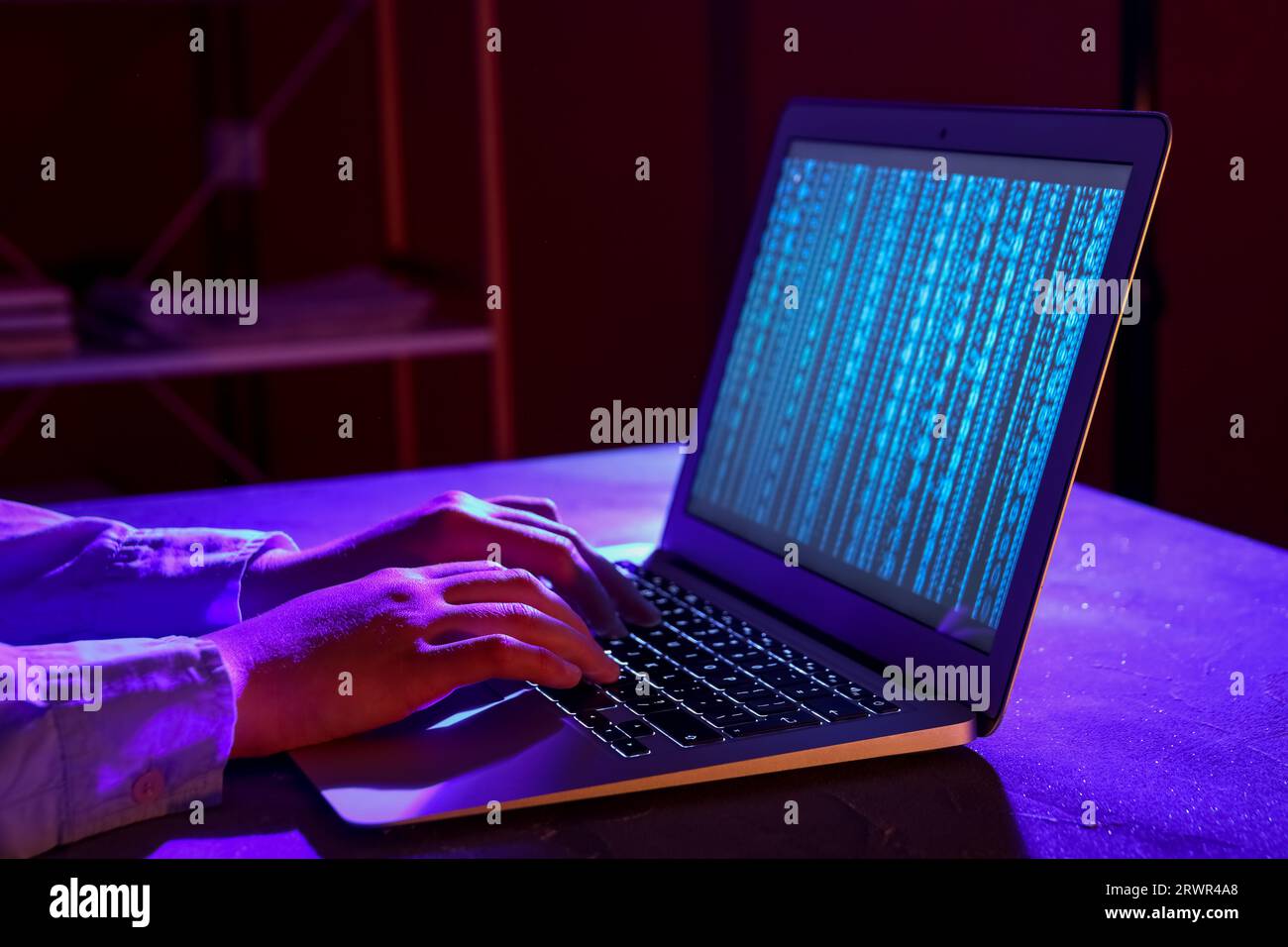 Female programmer typing on laptop keyboard at night in office, closeup ...