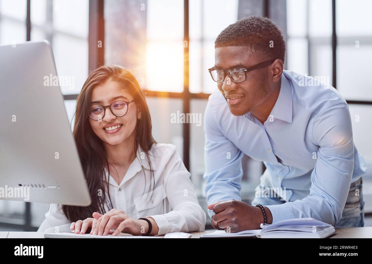 Cheerful multiracial colleagues discussing startup project and smiling ...