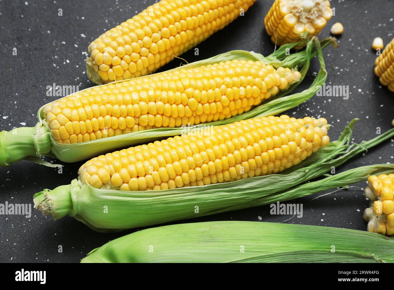 Fresh corn cobs on black table Stock Photo - Alamy