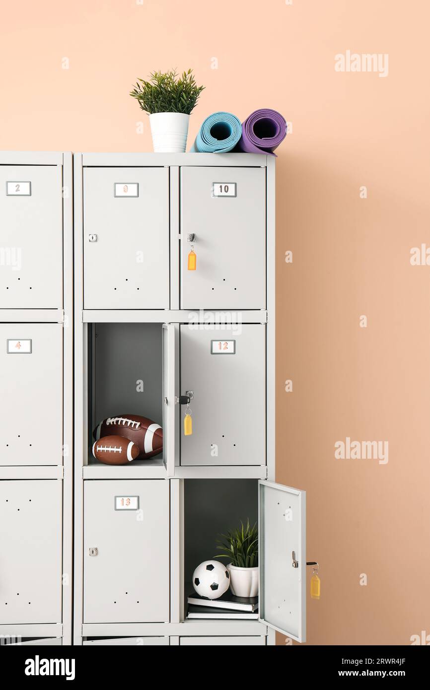 Modern locker with sports equipment near beige wall Stock Photo - Alamy