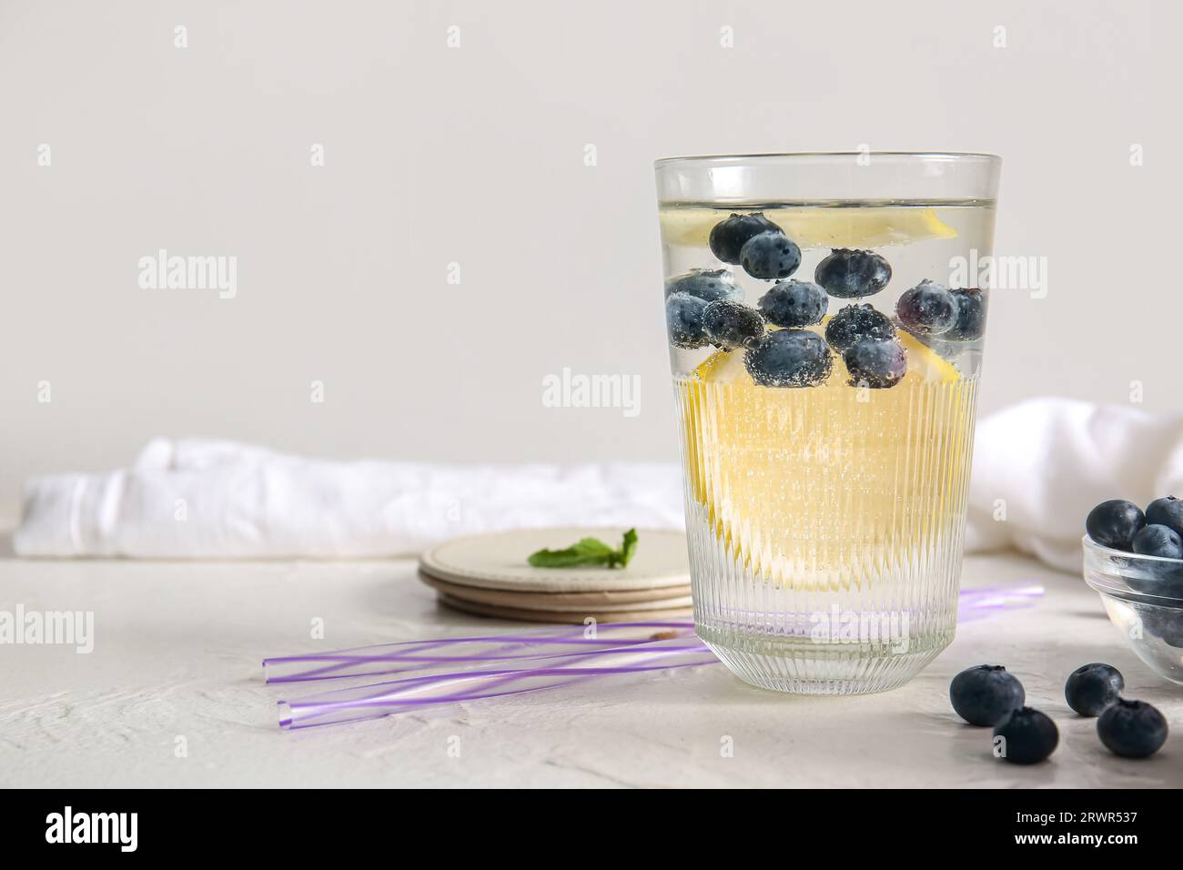 Glass of fresh blueberry lemonade on white background Stock Photo - Alamy