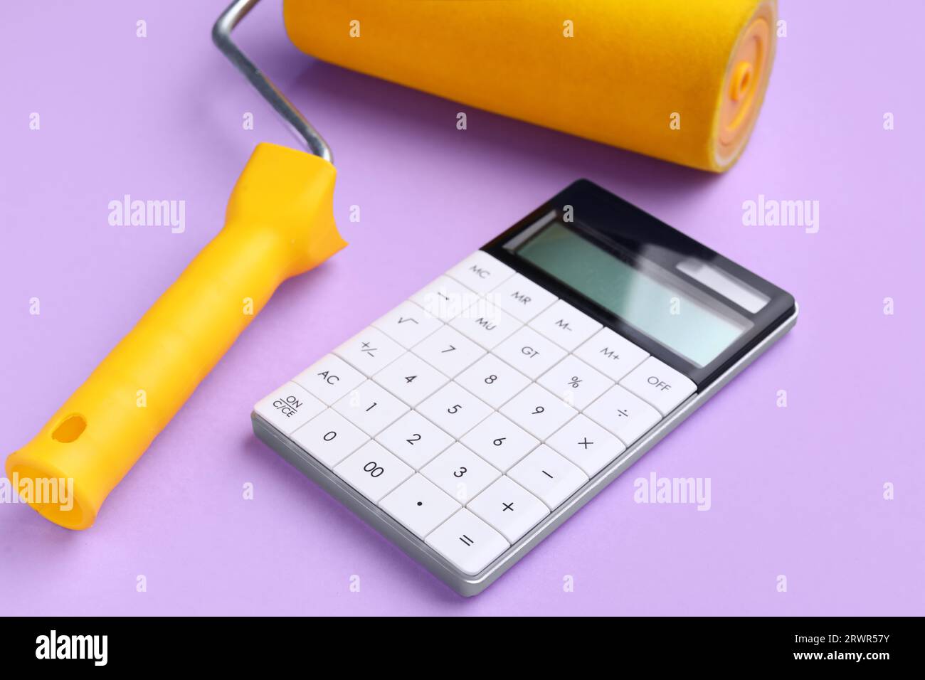 Paint roller and calculator on lilac background. Renovation budget ...