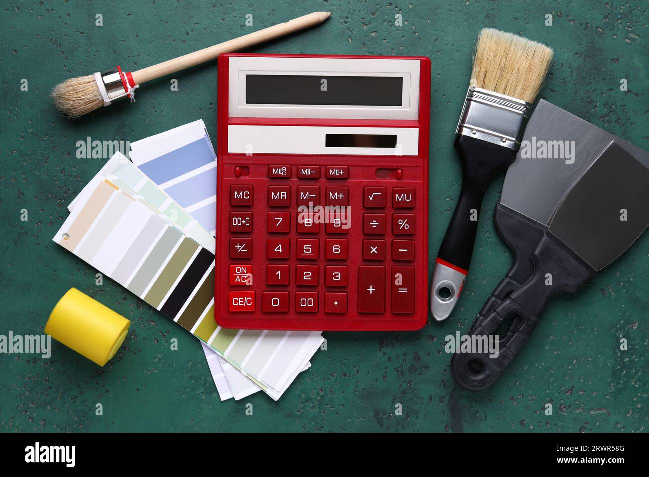 Composition with calculator, painting tools and color samples on green ...