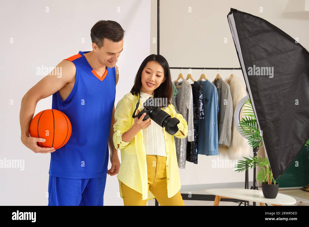 Female photographer working with basketball player in studio Stock ...