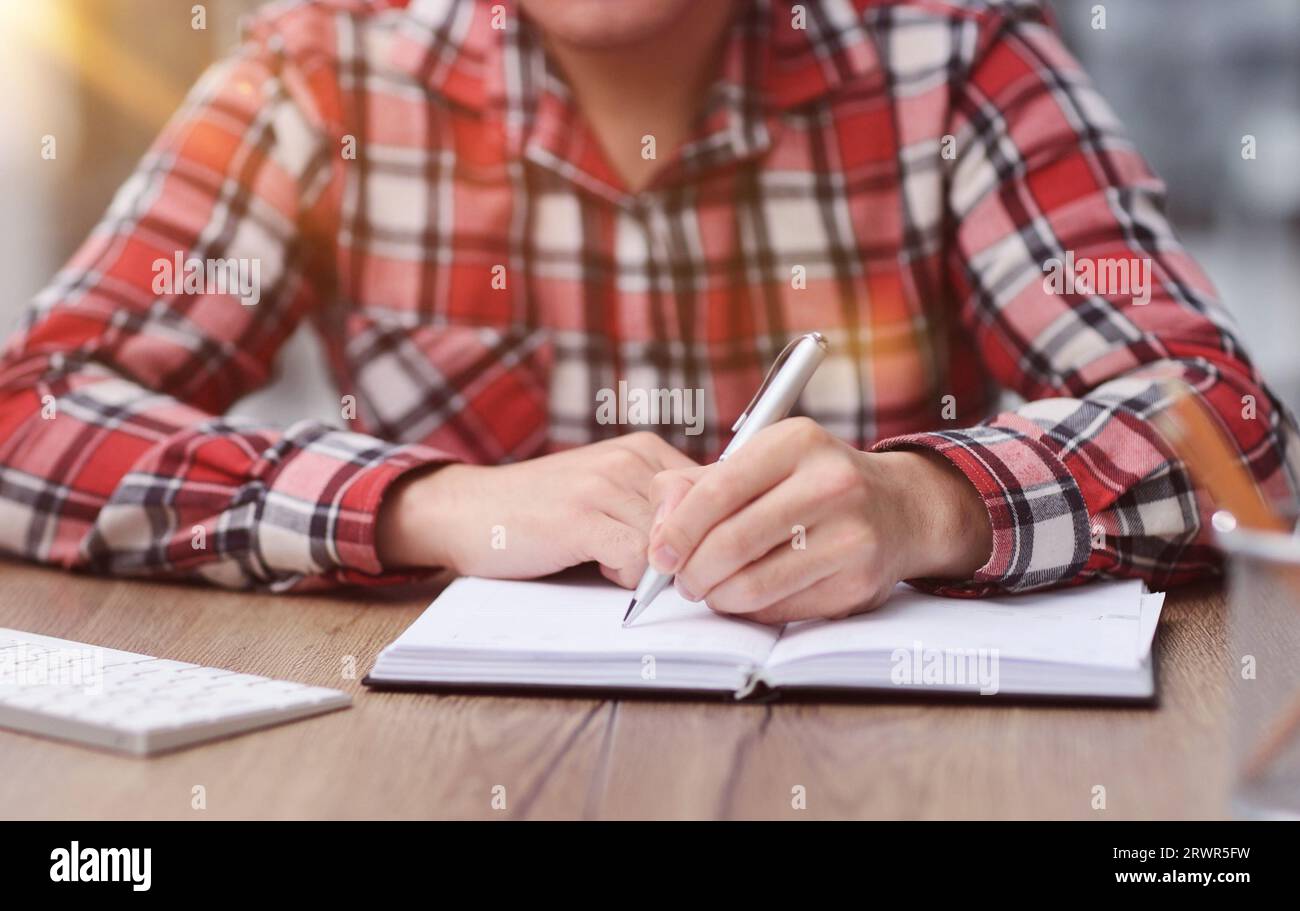 People write on a notepad and work in the office on a wooden table ...