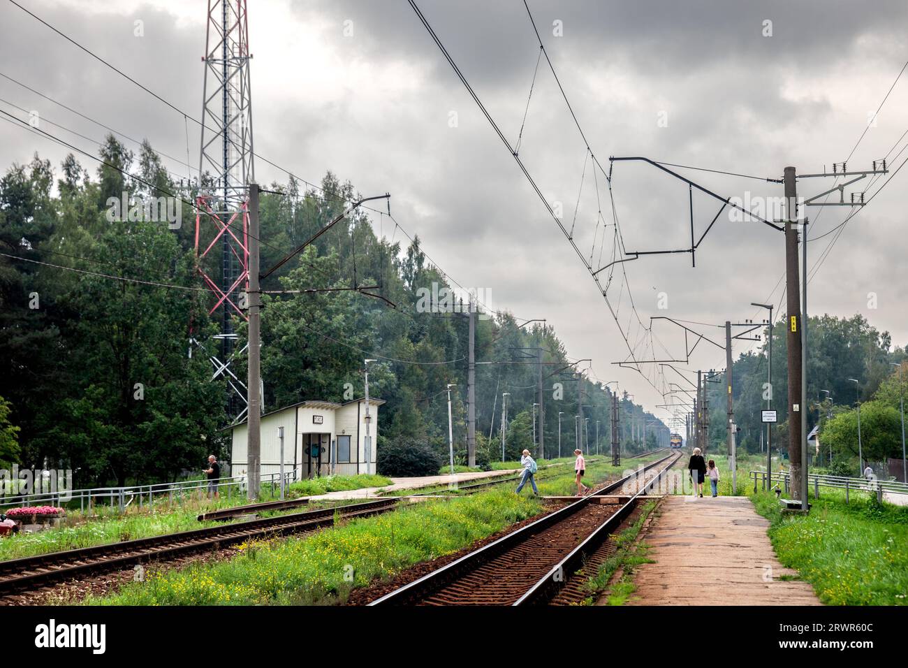 PIcture of people crossing the trains of Garciems train station, while ...