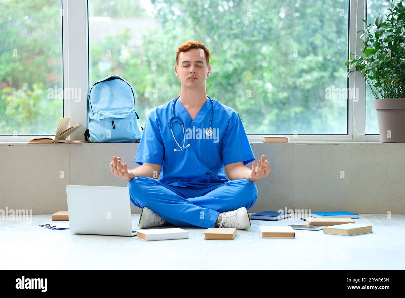Male medical student meditating at university Stock Photo - Alamy