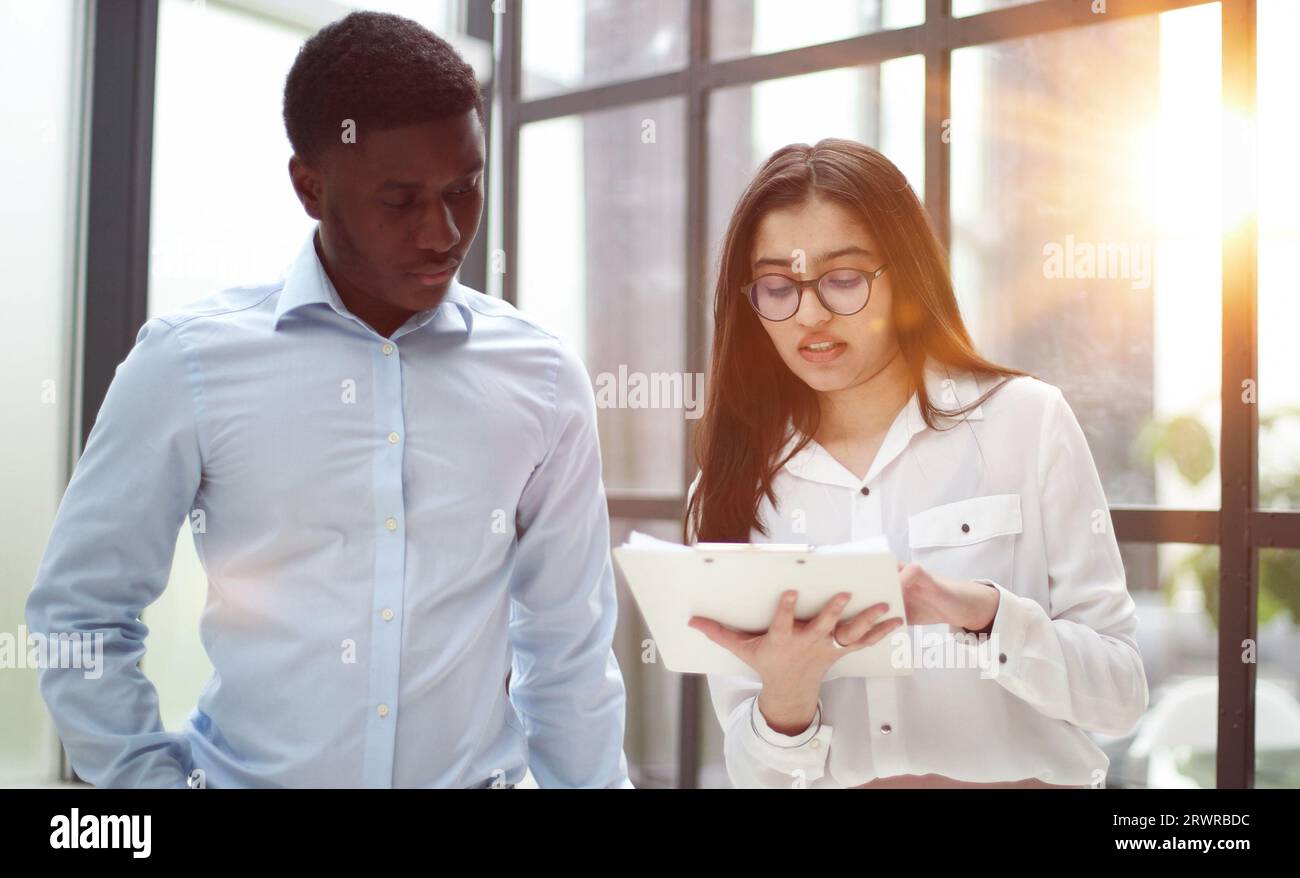 Office coworkers discussing in hallway hi-res stock photography and ...