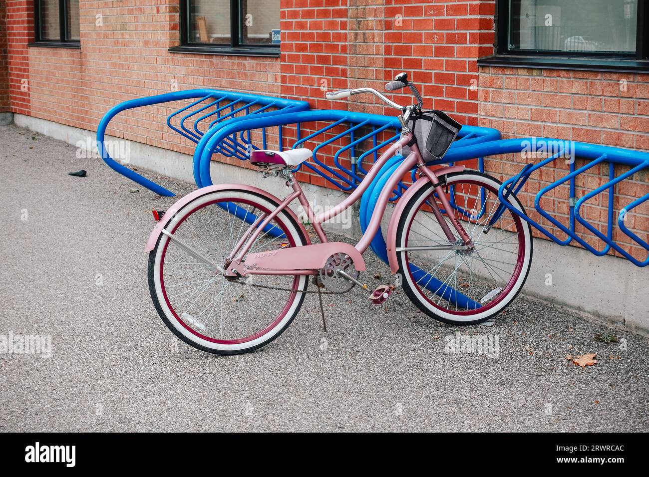 a pink vintage bicycle parked by a brick wall Stock Photo - Alamy