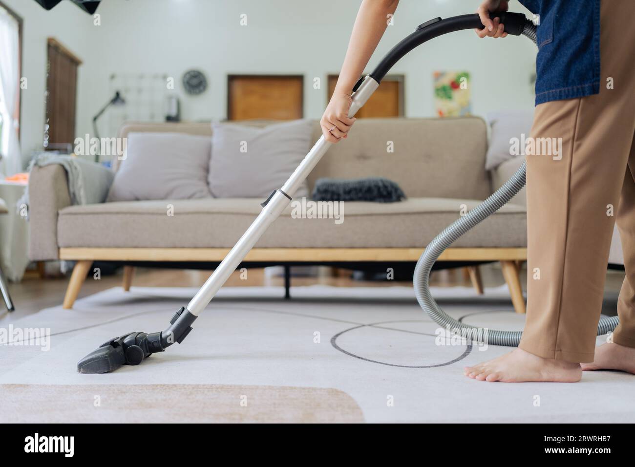 Beautiful young girl housekeeper cleaner wear apron and vacuuming messy ...