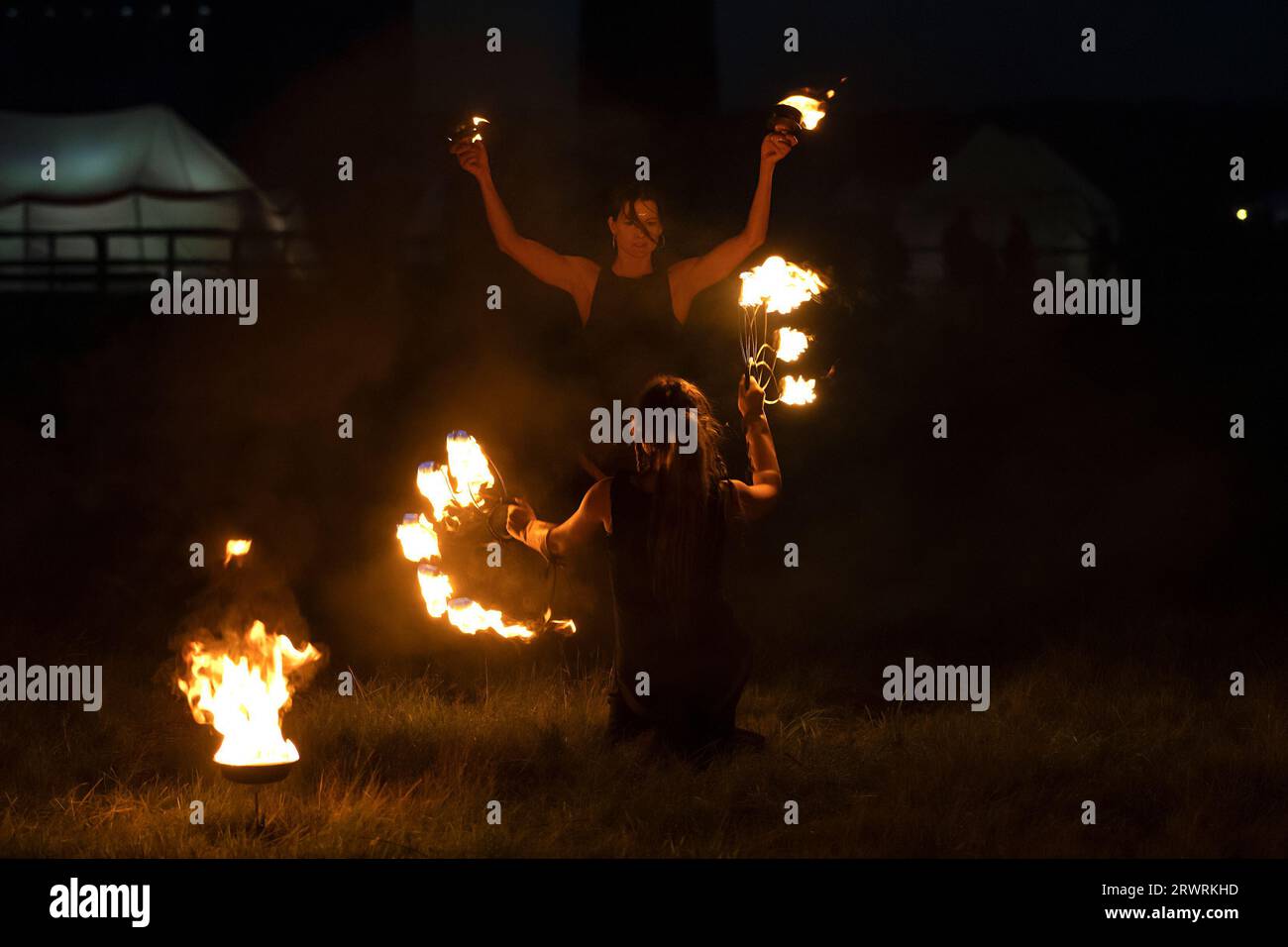 TVER REGION, RUSSIA - JULY 21, 2023: Two girls dance with fire. A fragment of the fire show on ...