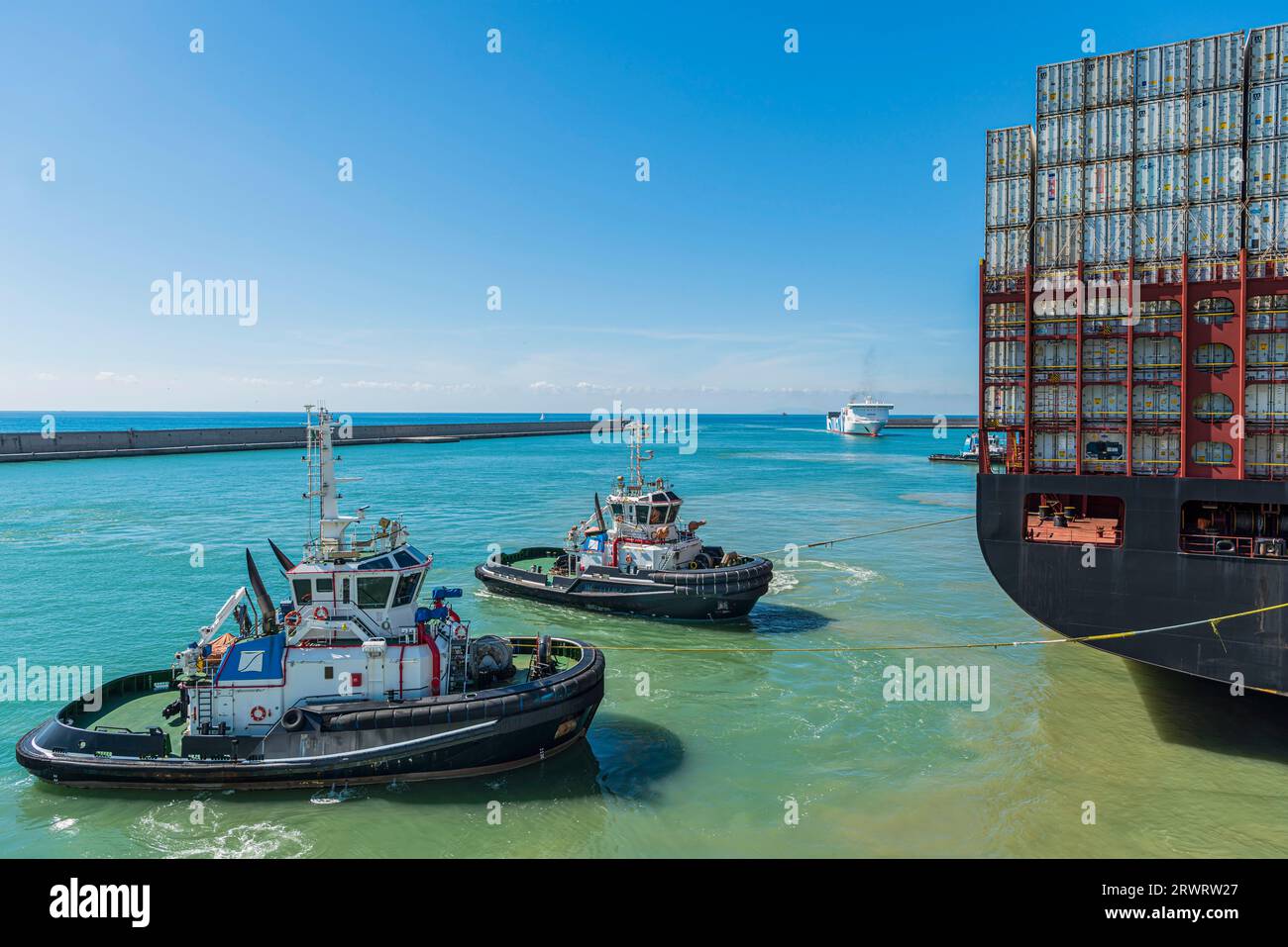 Container ship with tugboats in the harbour Stock Photo - Alamy
