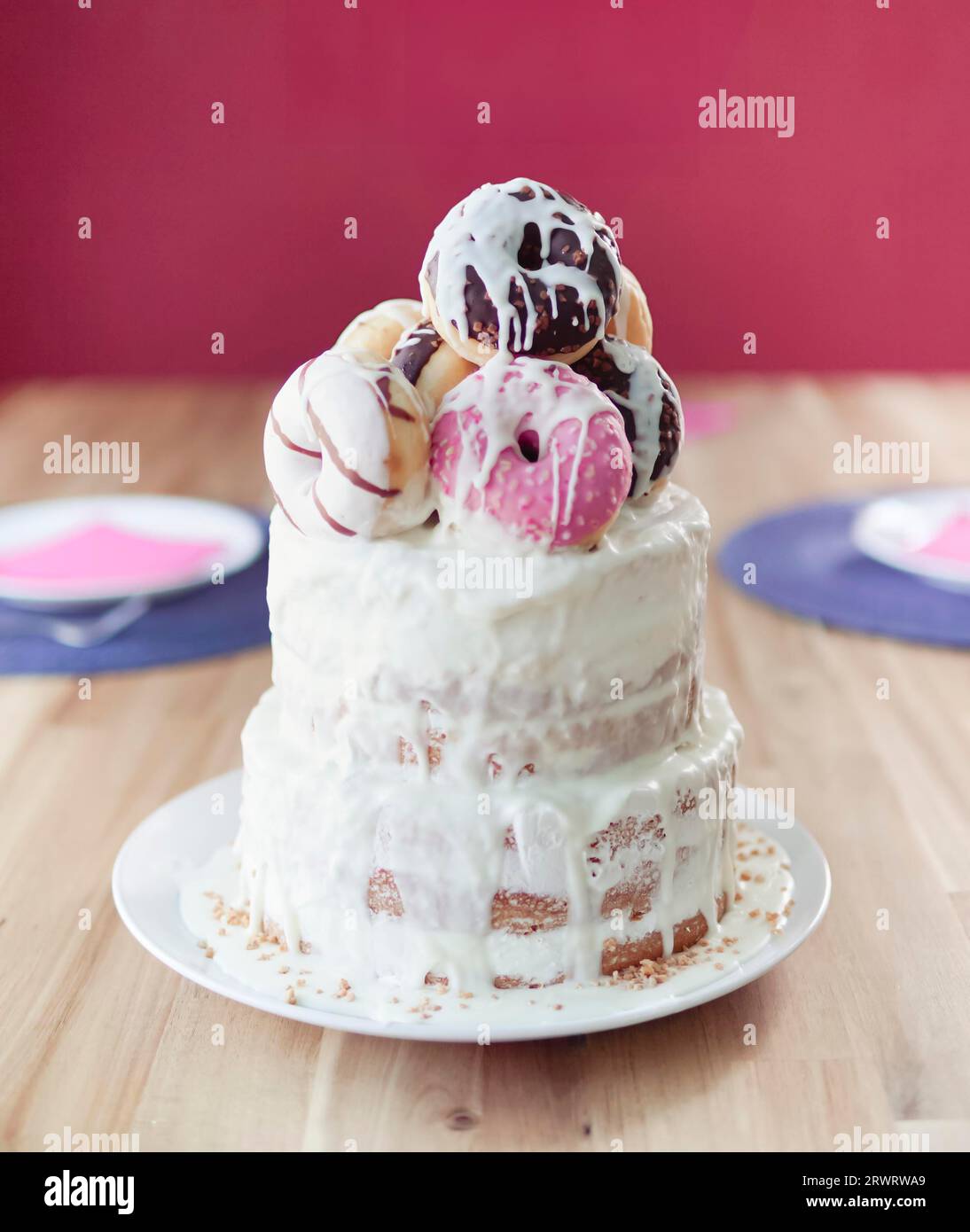 Huge, appetising, tall cake with donuts and melted icing for a ...