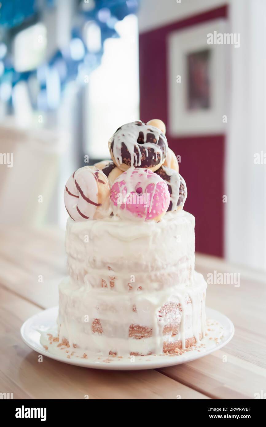 Huge, appetising, tall cake with donuts and melted icing for a ...