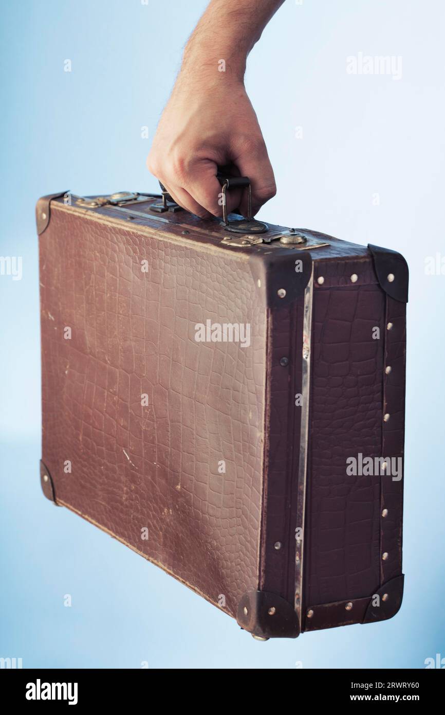 Hand carrying an old suitcase Stock Photo - Alamy