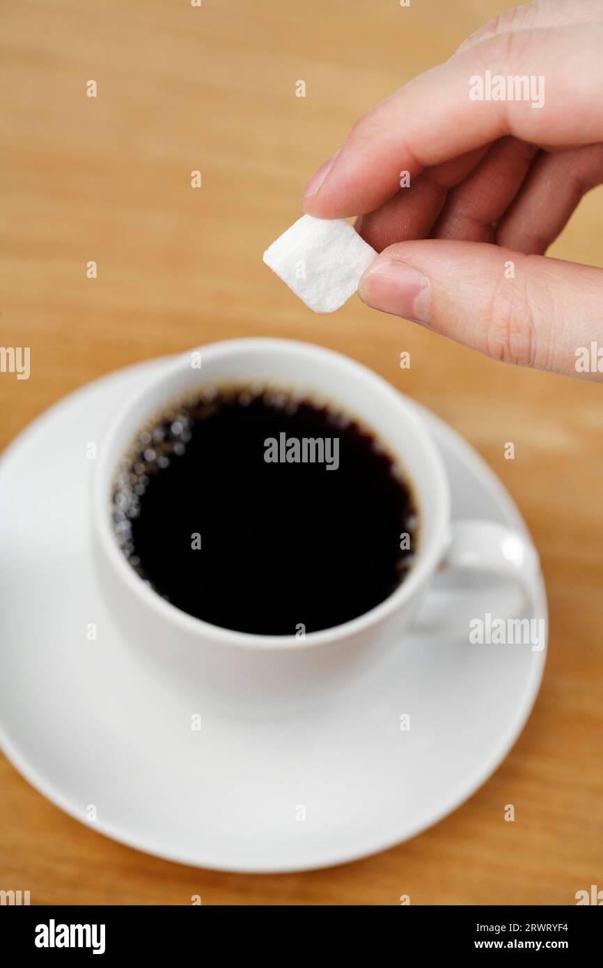 Hand putting sugar cube hi-res stock photography and images - Alamy